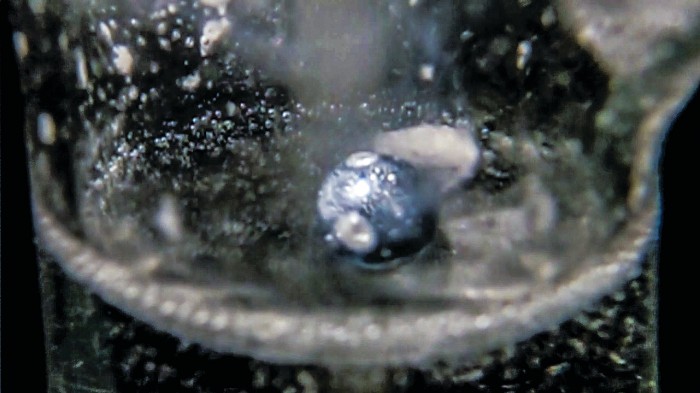 Liquid alkali metal alloy floats on water rather than explodes